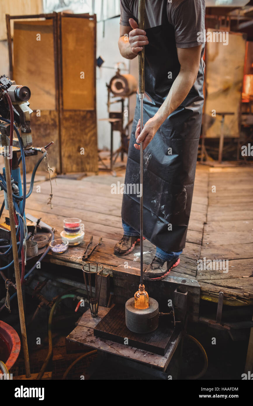 Glassblower using mold to shape a molten glass Stock Photo - Alamy