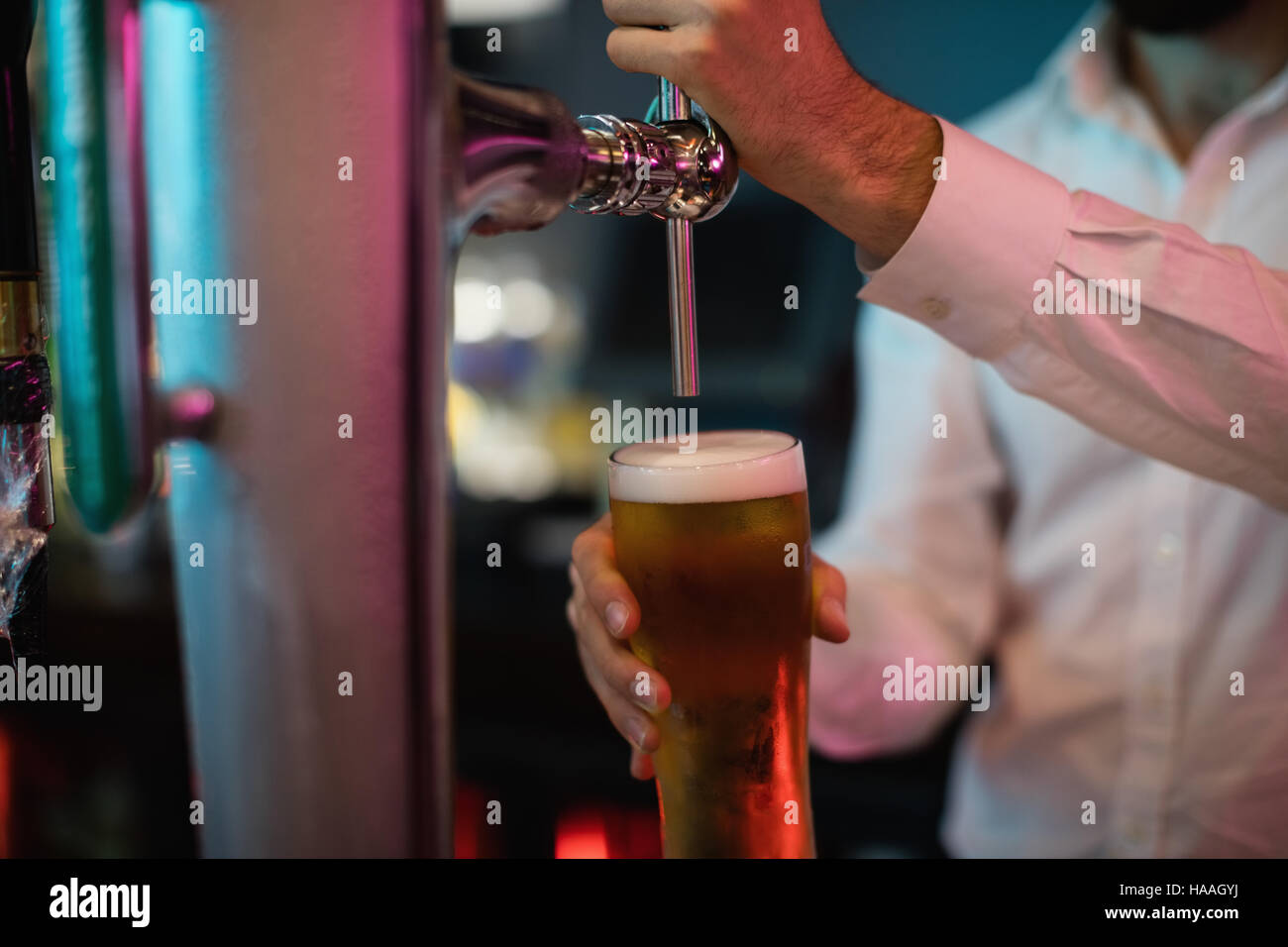 Bartender filling beer from bar pump Stock Photo - Alamy