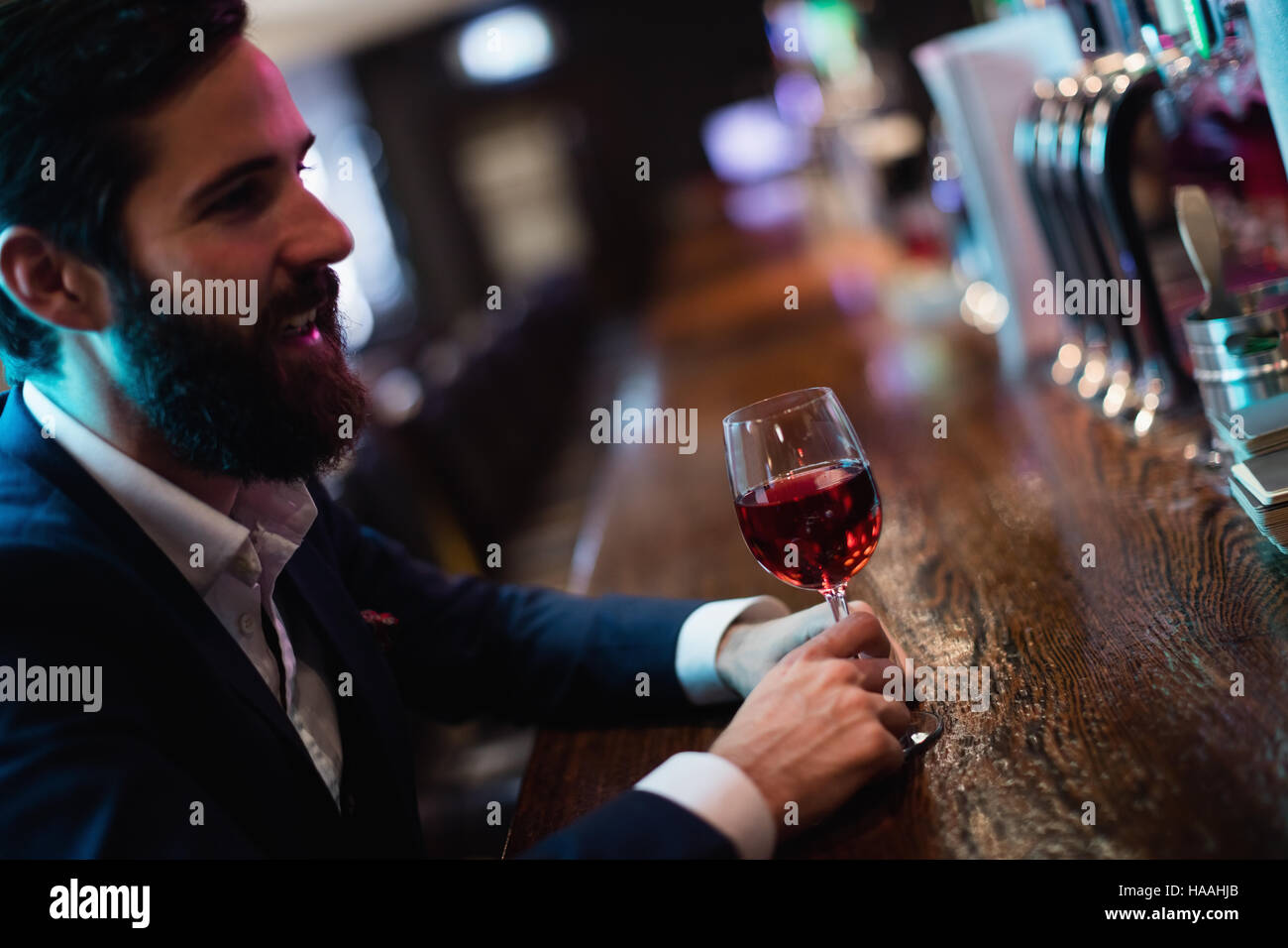 Businessman having glass of wine on counter Stock Photo - Alamy