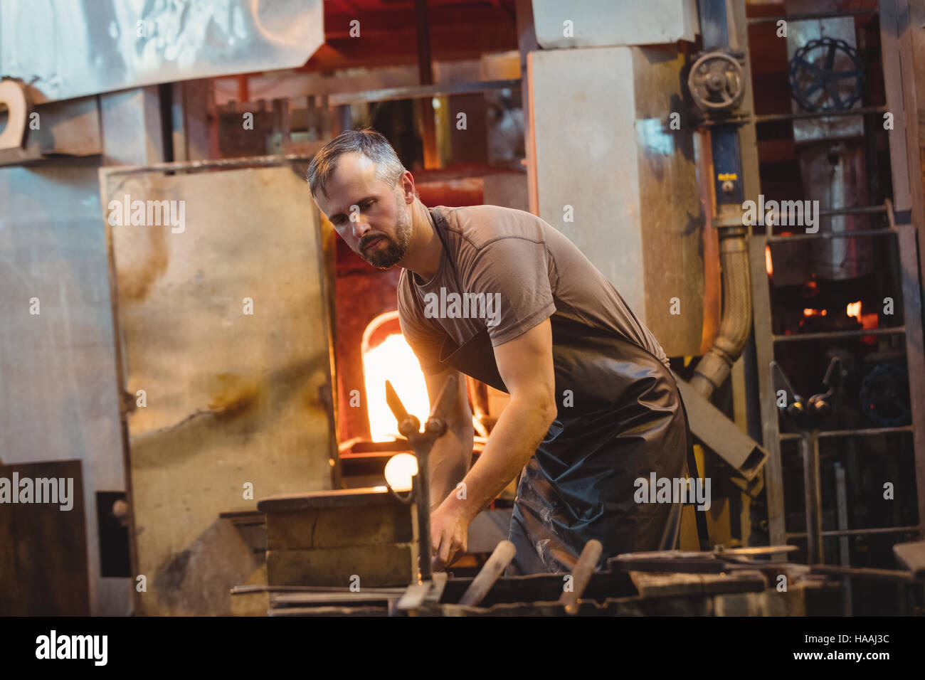 Glassblower shaping a molten glass Stock Photo - Alamy