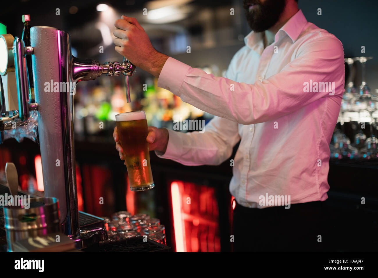 Bartender filling beer from bar pump Stock Photo - Alamy
