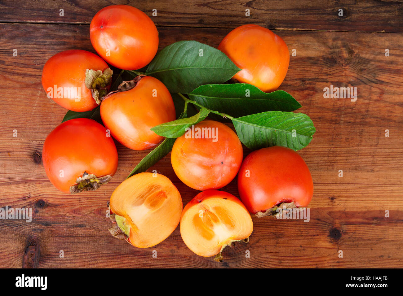 Persimmon kaki fruits over wooden background. Top view Stock Photo - Alamy