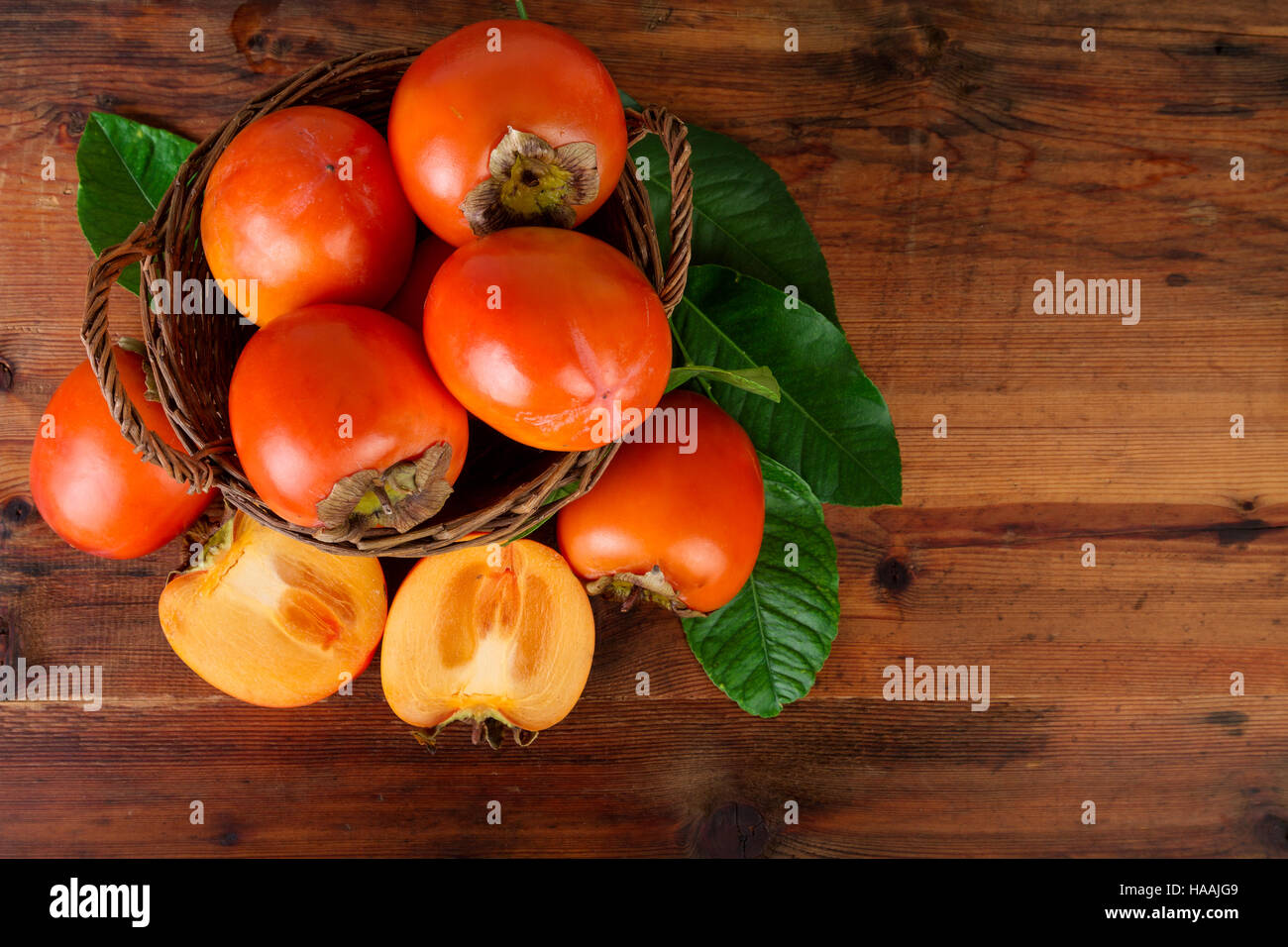 Persimmon fruits in wicker basket. Top view Stock Photo - Alamy