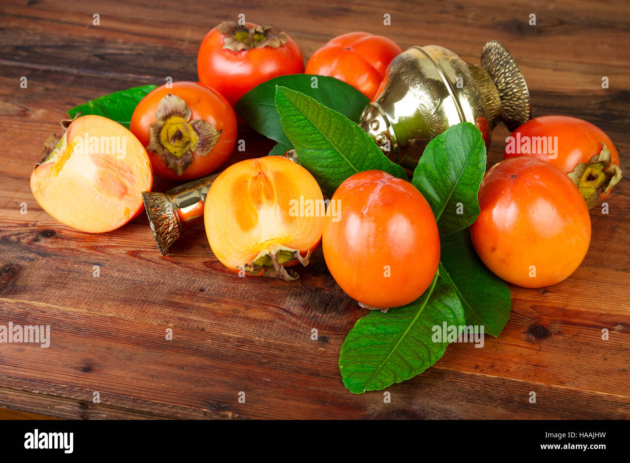 Persimmons kaki fruits with vintage brass vase. Oriental East Persian ...