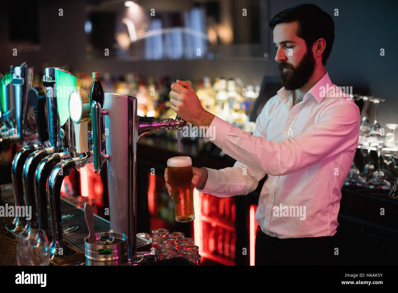 Bartender filling beer from bar pump Stock Photo - Alamy