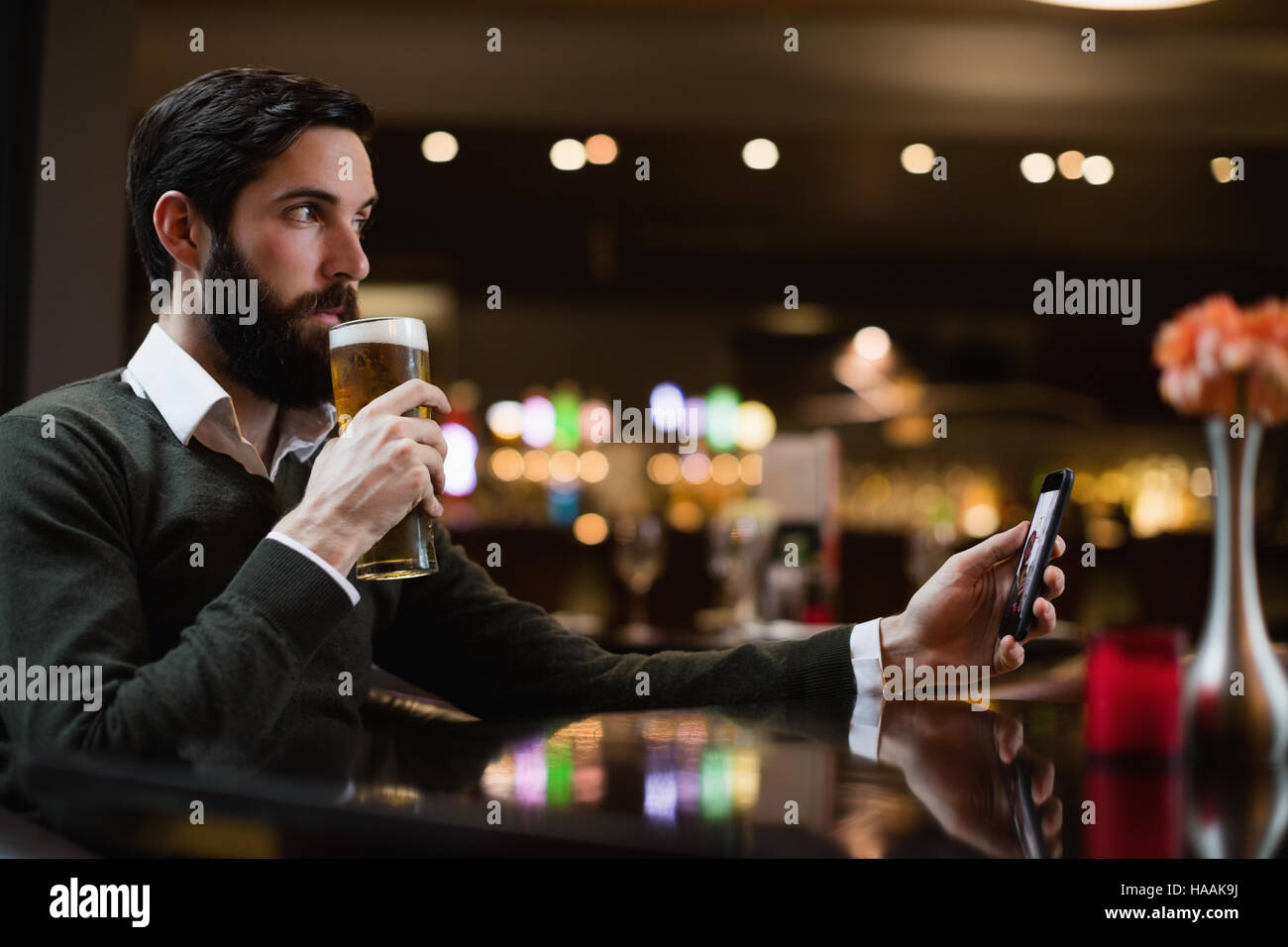 Man holding mobile phone and having glass of beer Stock Photo - Alamy