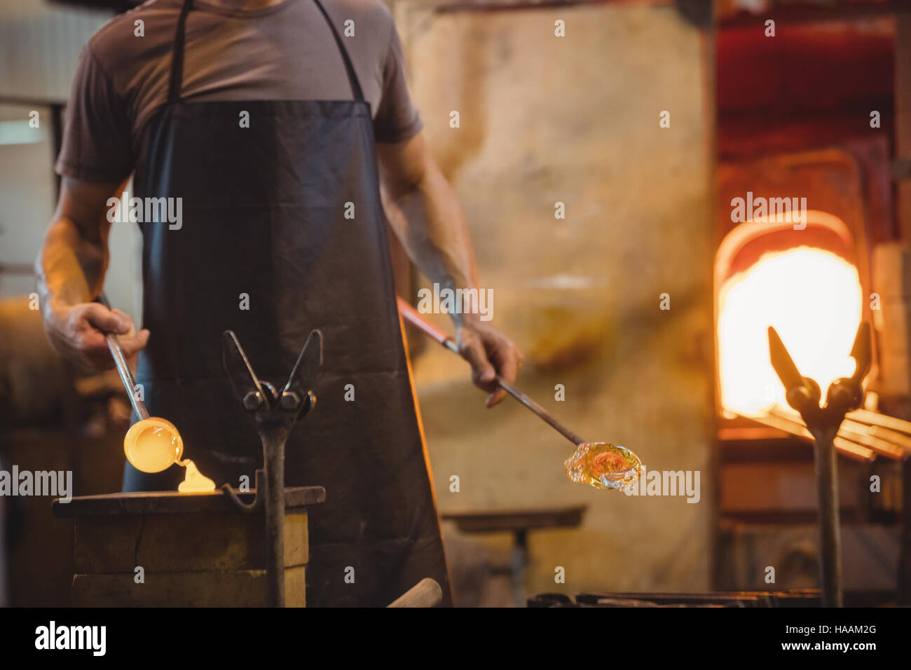 Glassblower shaping a molten glass Stock Photo - Alamy