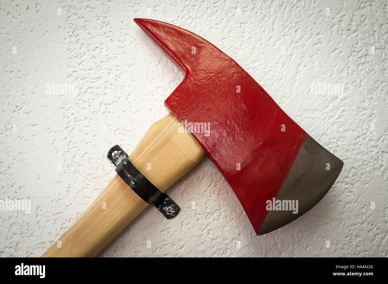 Closeup of fireman's red axe hanging on textured wall Stock Photo - Alamy
