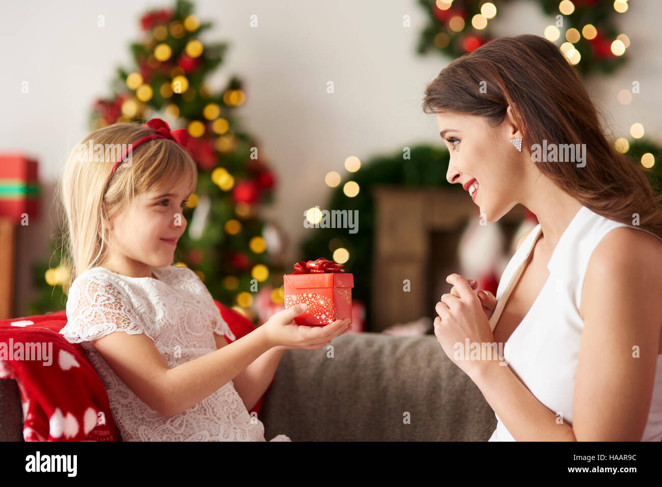Daughter handing over gift for mummy Stock Photo - Alamy