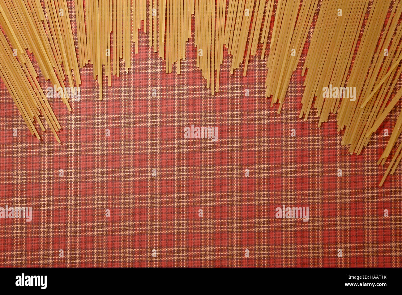 Yellow italian spaghetti pasta on red background Stock Photo - Alamy