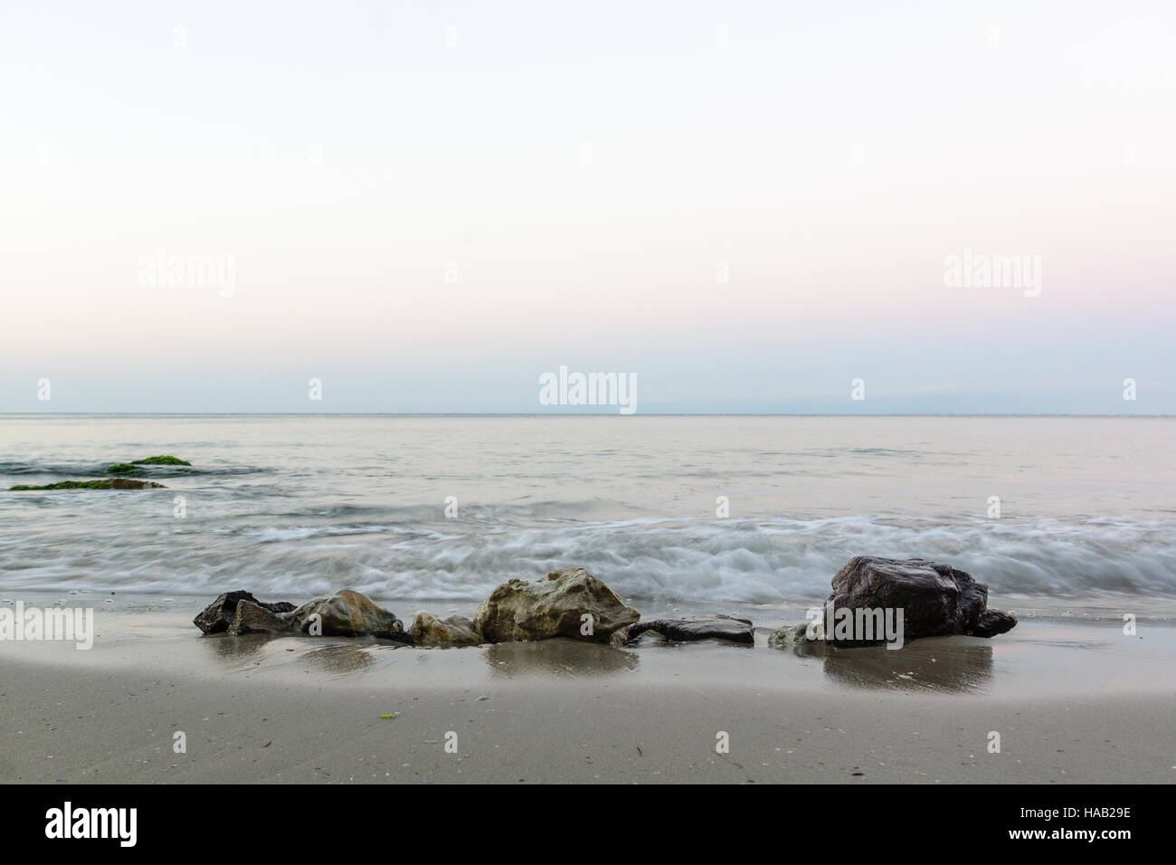stones on the beach under the incoming wave Stock Photo - Alamy