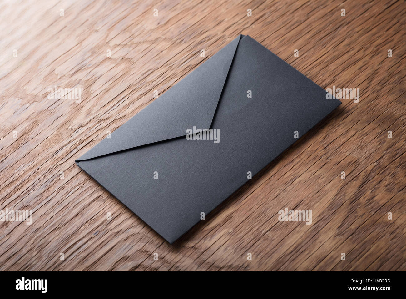 black envelope on wooden table Stock Photo - Alamy
