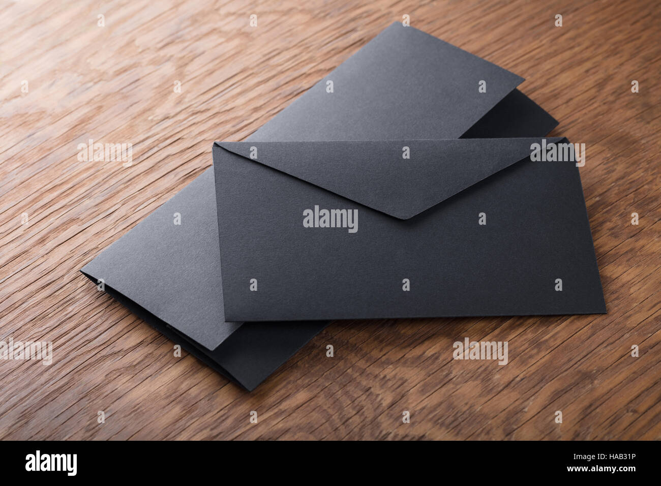 black envelope on wooden table Stock Photo - Alamy