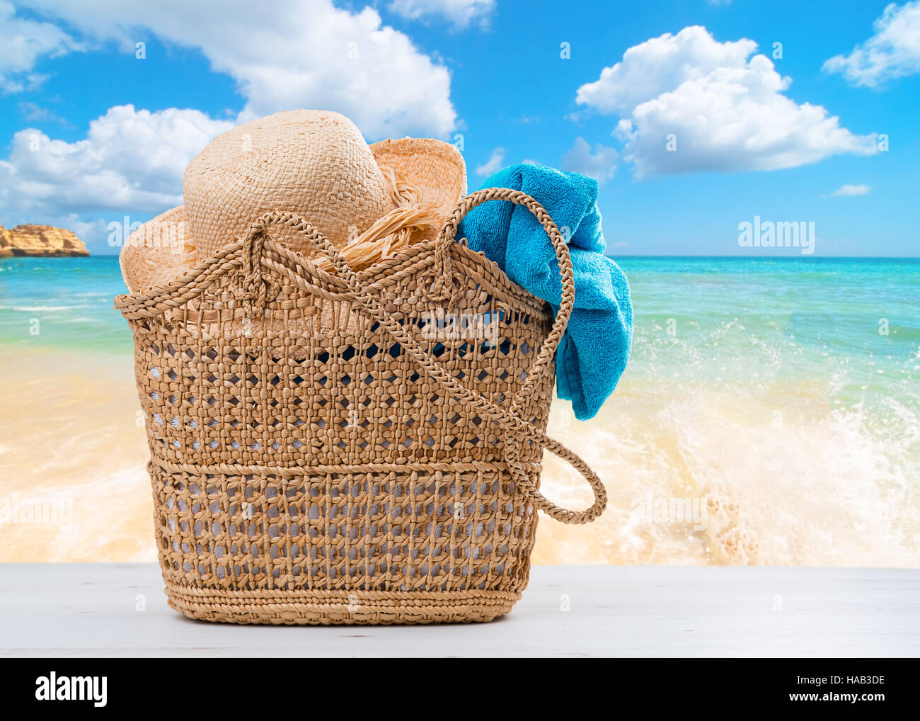 Beach basket packed with towel and sunhat with beach blur background ...