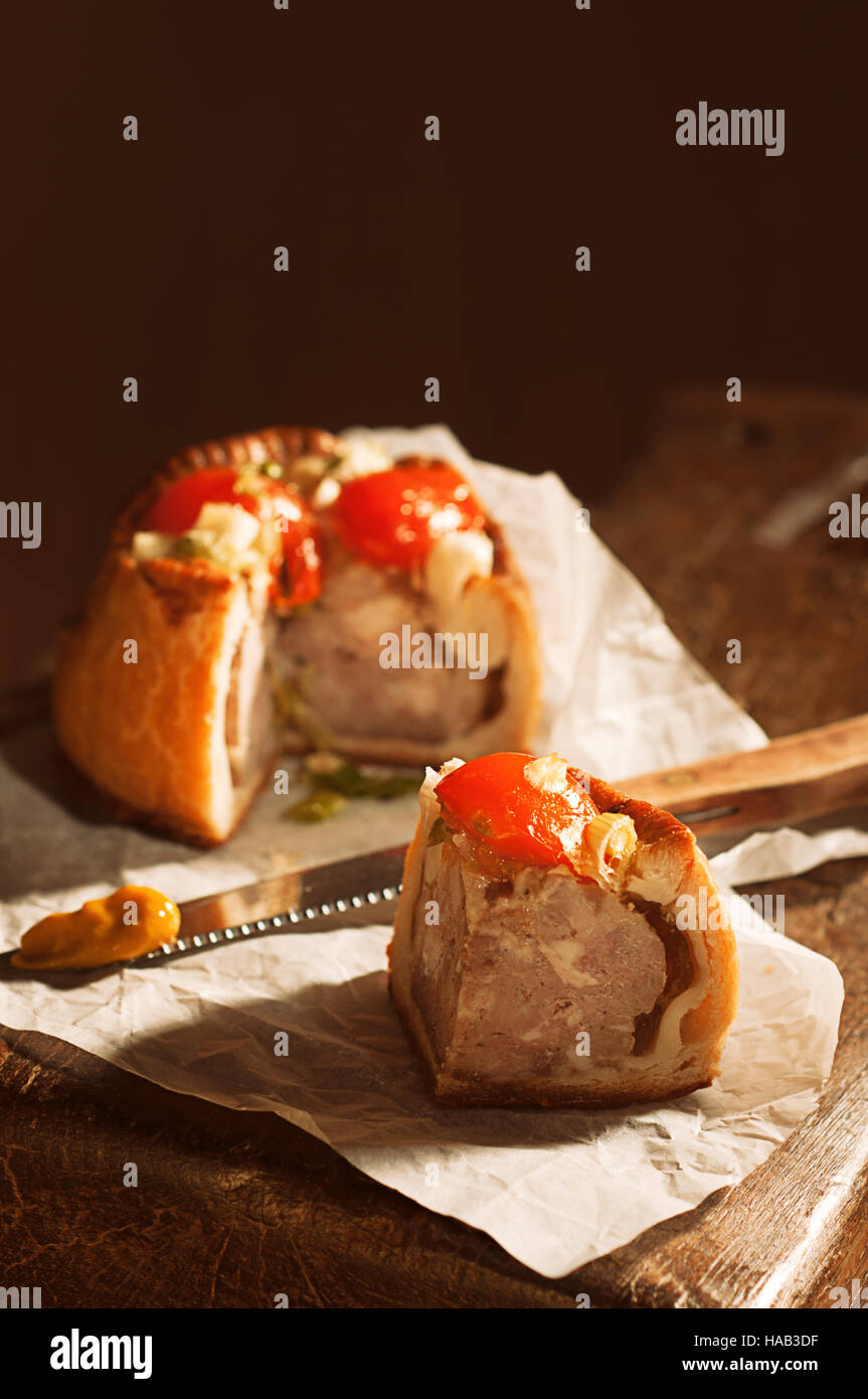 Slice of pork pie with knife loaded with mustard Stock Photo - Alamy