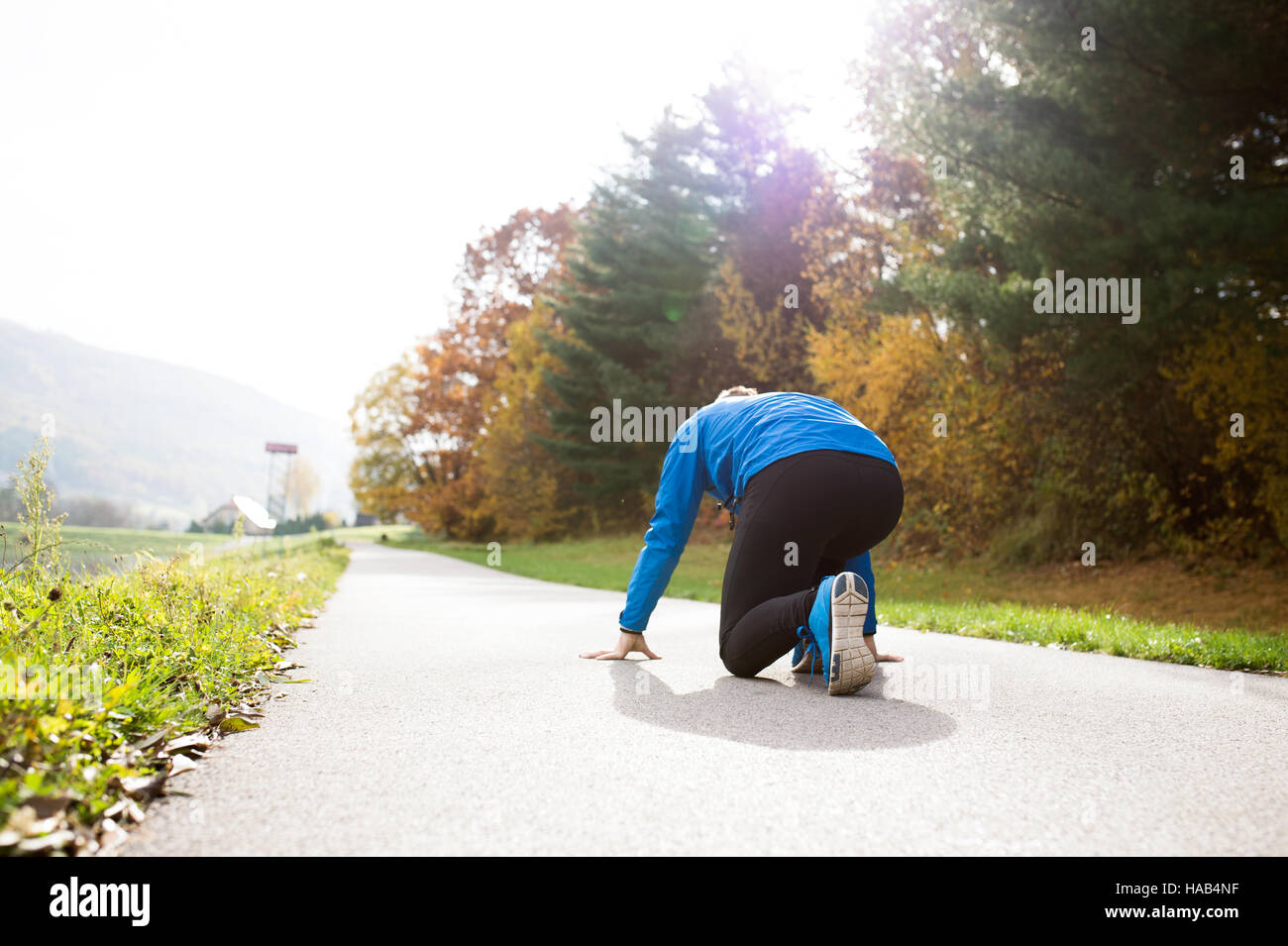 Runner at the lake on asphalt path in steady position Stock Photo - Alamy