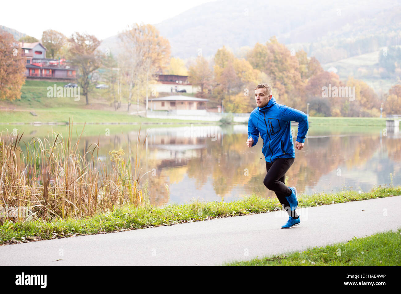 Athlete at the lake running against colorful autumn nature Stock Photo ...