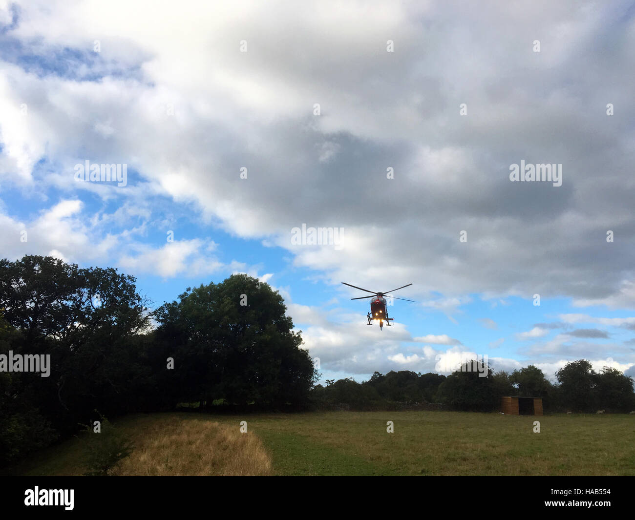 Wales Air Ambulance helicopter landing on top of riverbank to lift off ...
