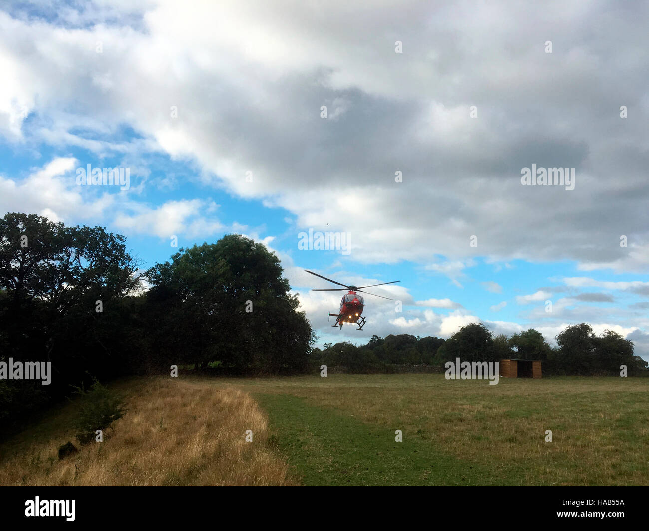 Wales Air Ambulance helicopter landing on top of riverbank to lift off ...