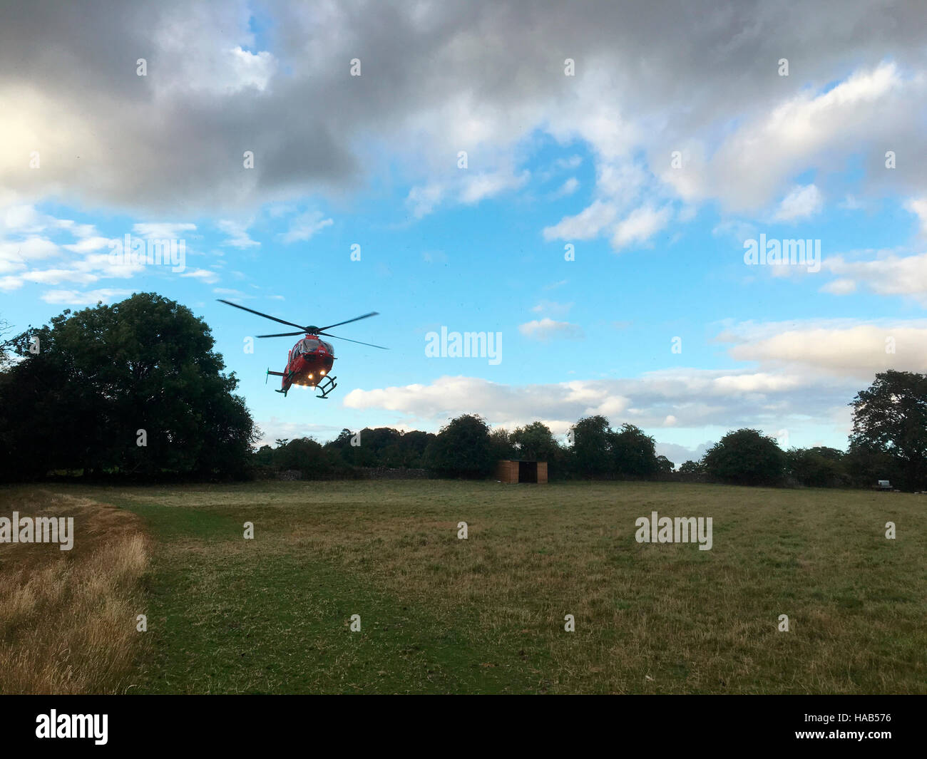 Wales Air Ambulance helicopter taking off from top of riverbank with ...