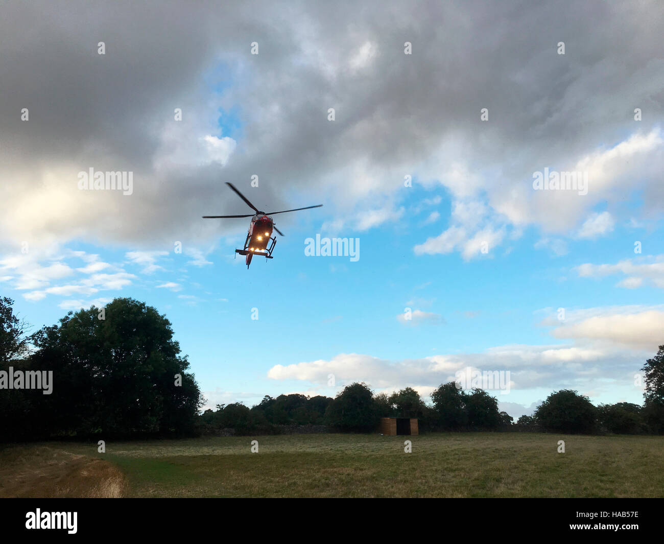 Wales Air Ambulance helicopter taking off from top of riverbank with ...