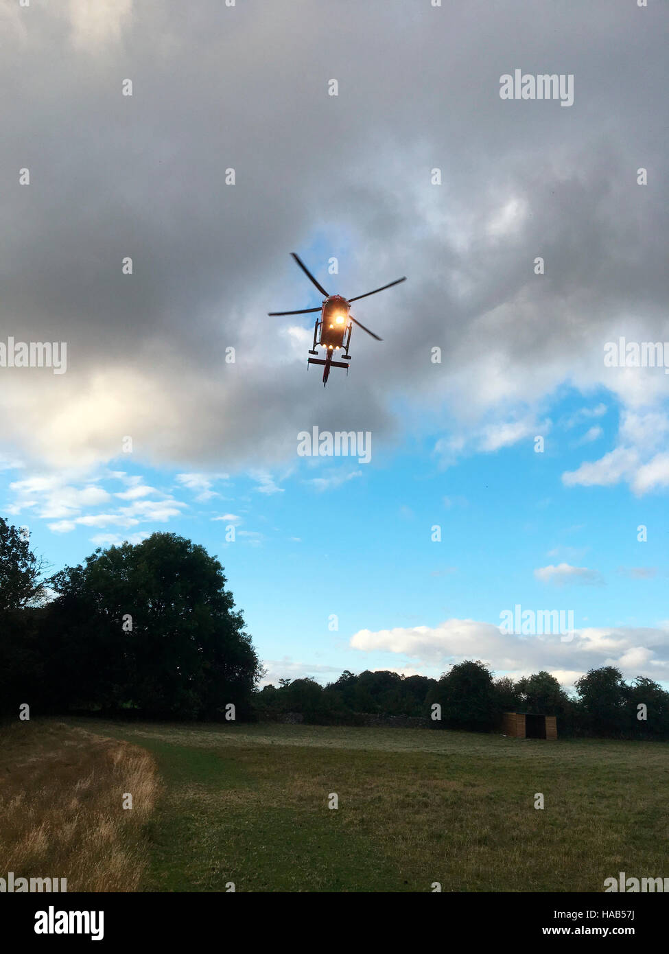 Wales Air Ambulance helicopter taking off from top of riverbank with ...