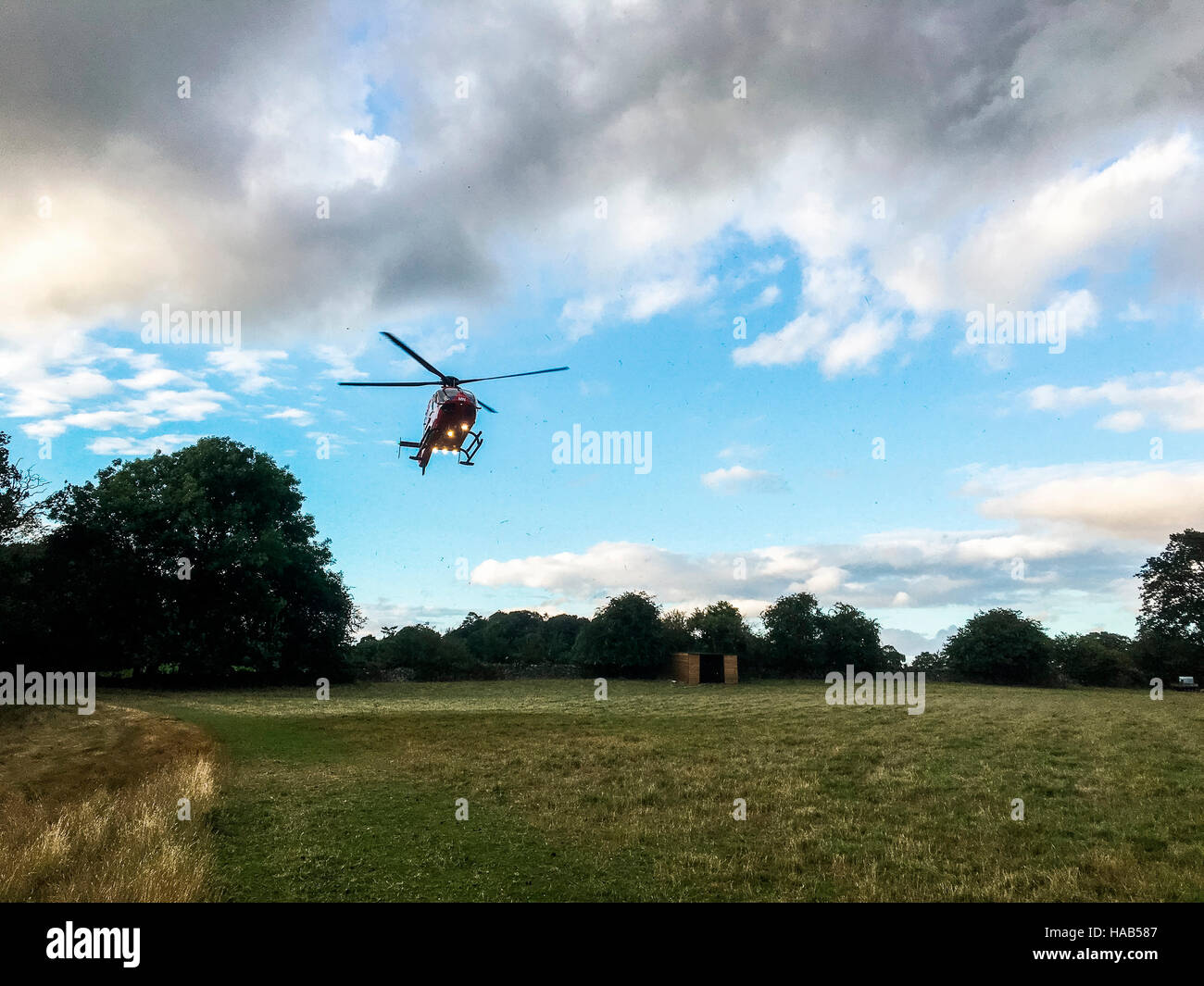 Wales Air Ambulance helicopter taking off from top of riverbank with ...