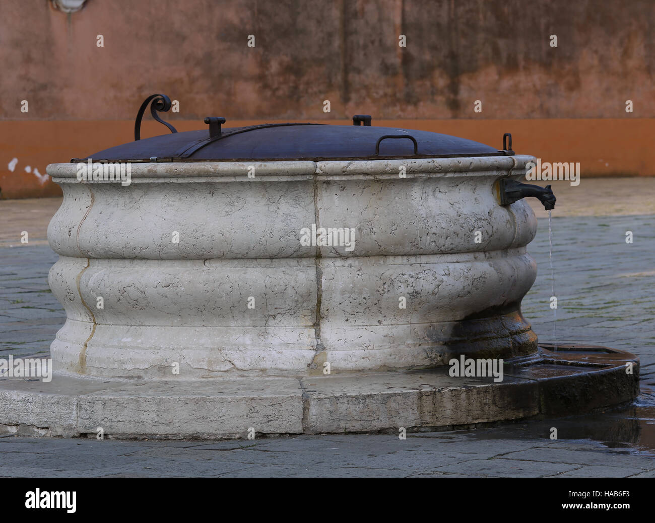 large medieval well in circular form in the square of an old European ...