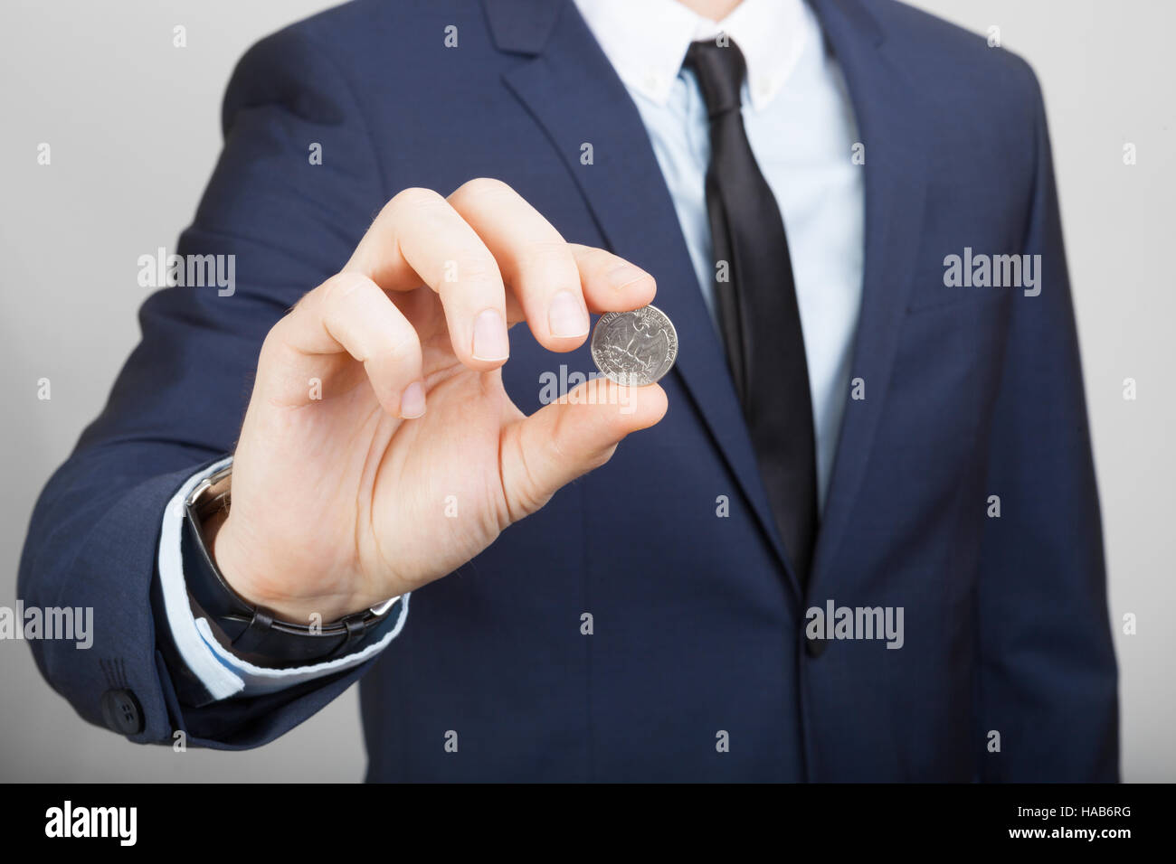 Businessman in neat suit holding 25 US cents coin in hand Stock Photo ...