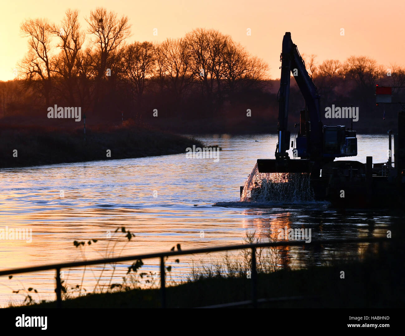 Rosslau, GErmany. 29th Nov, 2016. A mechanical digger on a floating ...