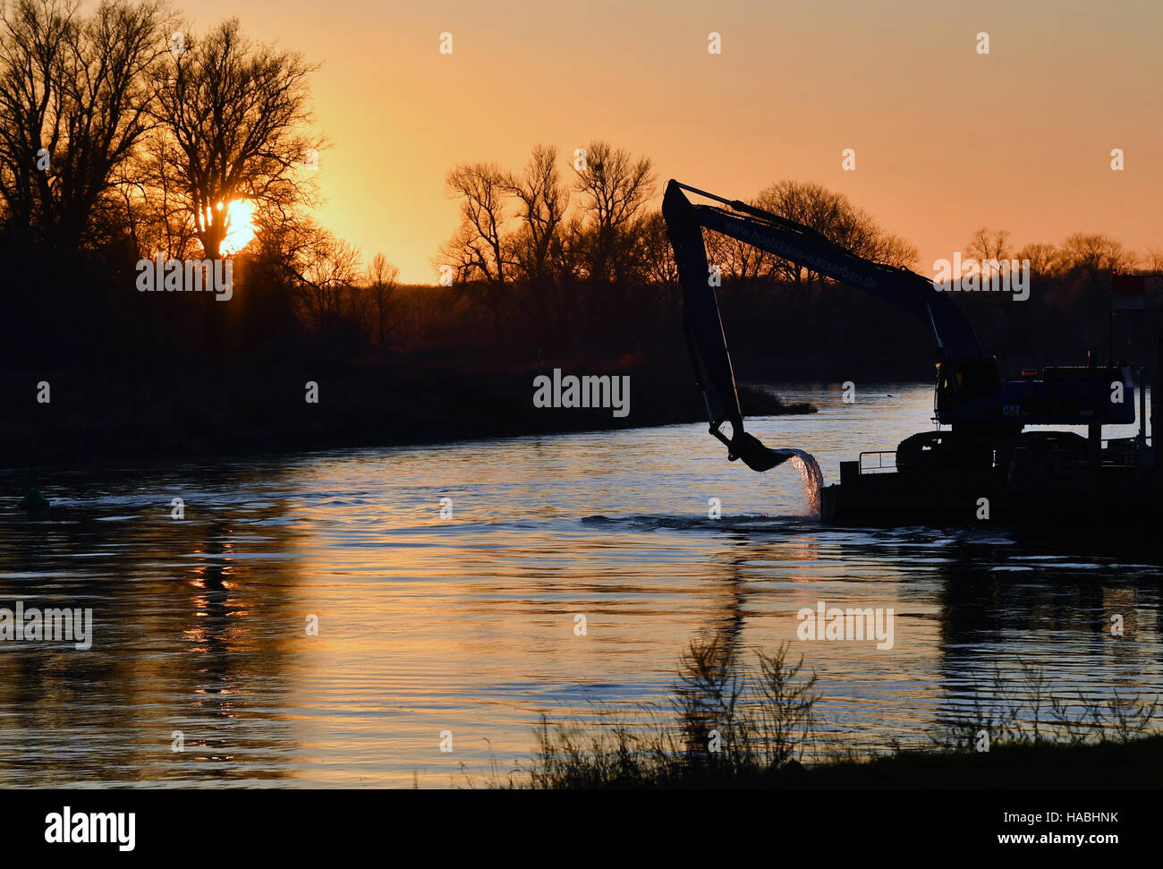 Rosslau, GErmany. 29th Nov, 2016. A mechanical digger on a floating ...