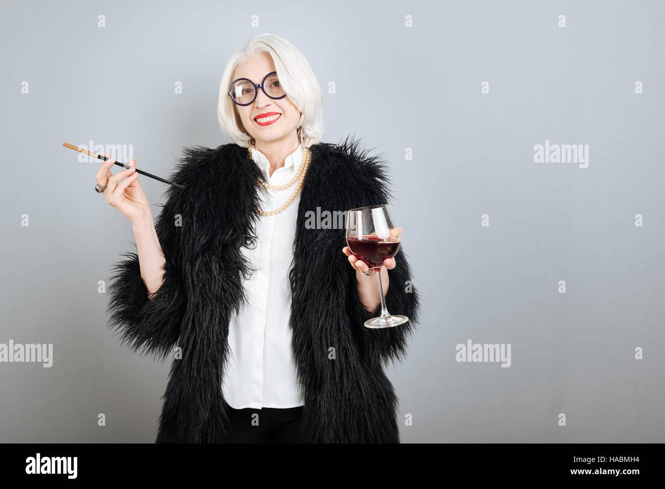 Smiling senior woman smoking cigarette Stock Photo - Alamy