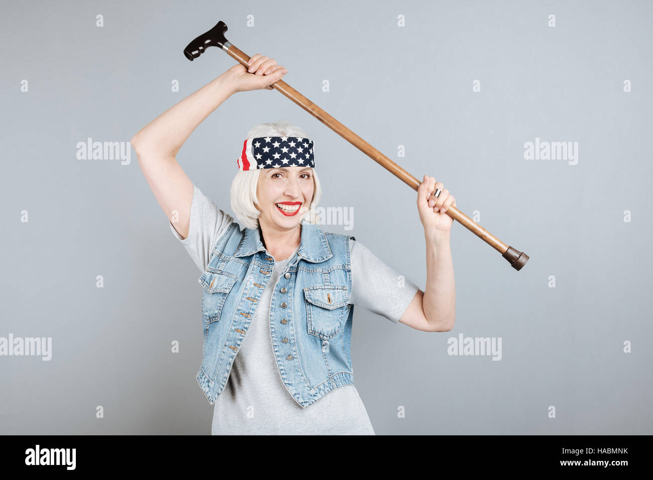 Charming emotional senior lady holding stick Stock Photo - Alamy