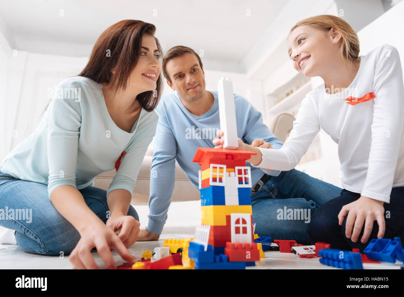 Delighted joyful family playing with construction blocks Stock Photo ...