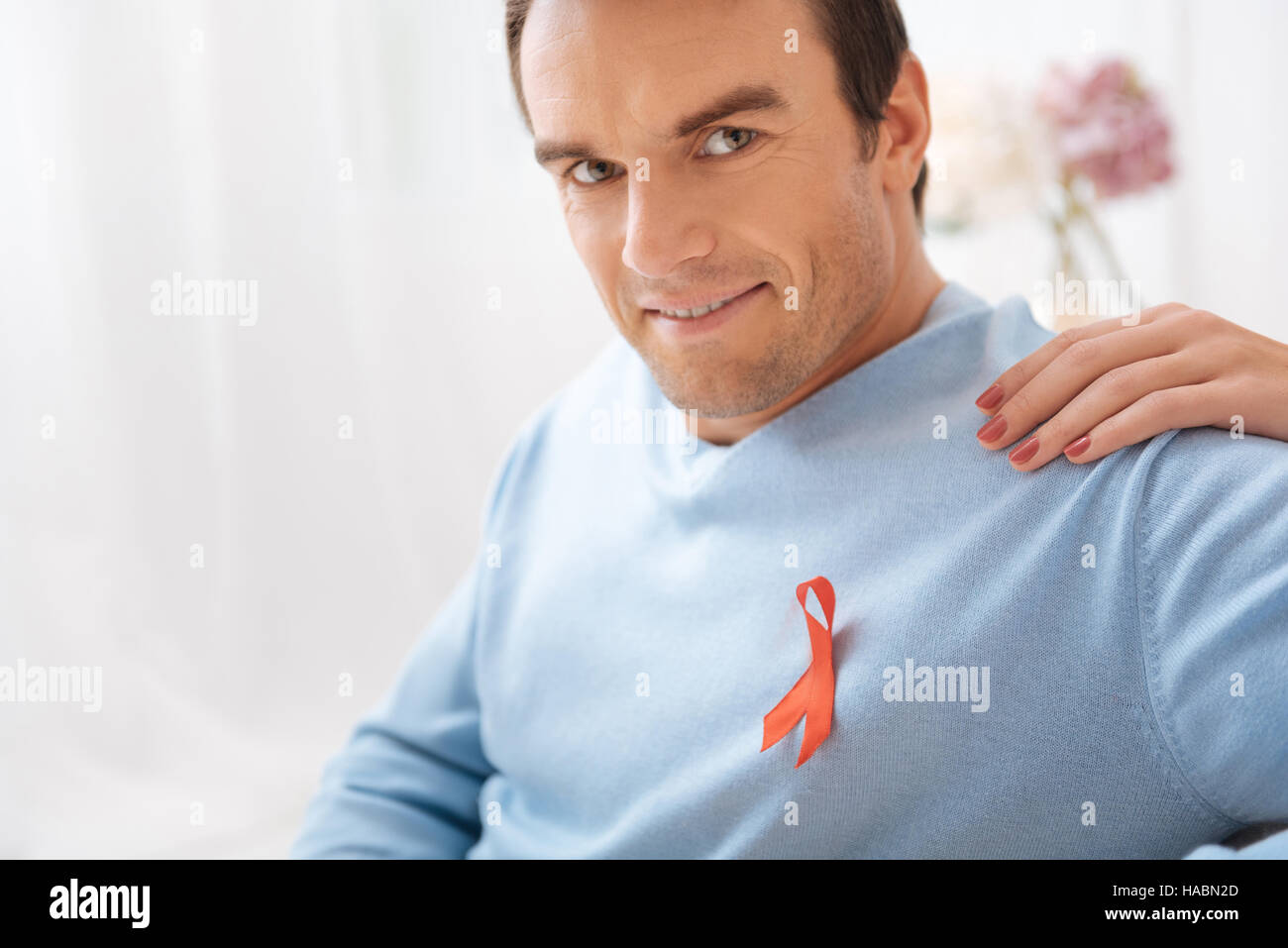 Handsome positive man wearing a red ribbon Stock Photo - Alamy