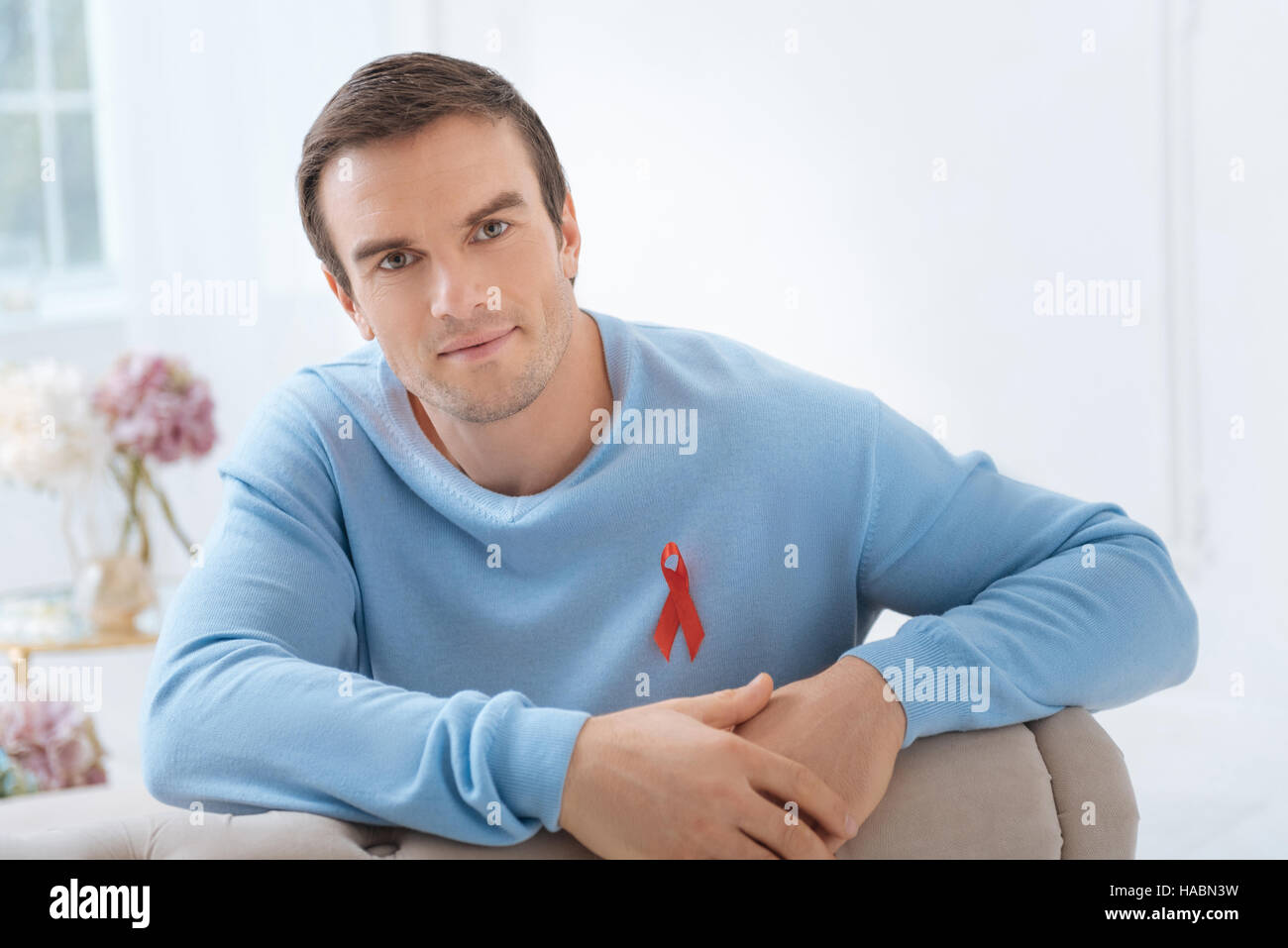 Pleasant handsome man wearing AIDS sign Stock Photo - Alamy
