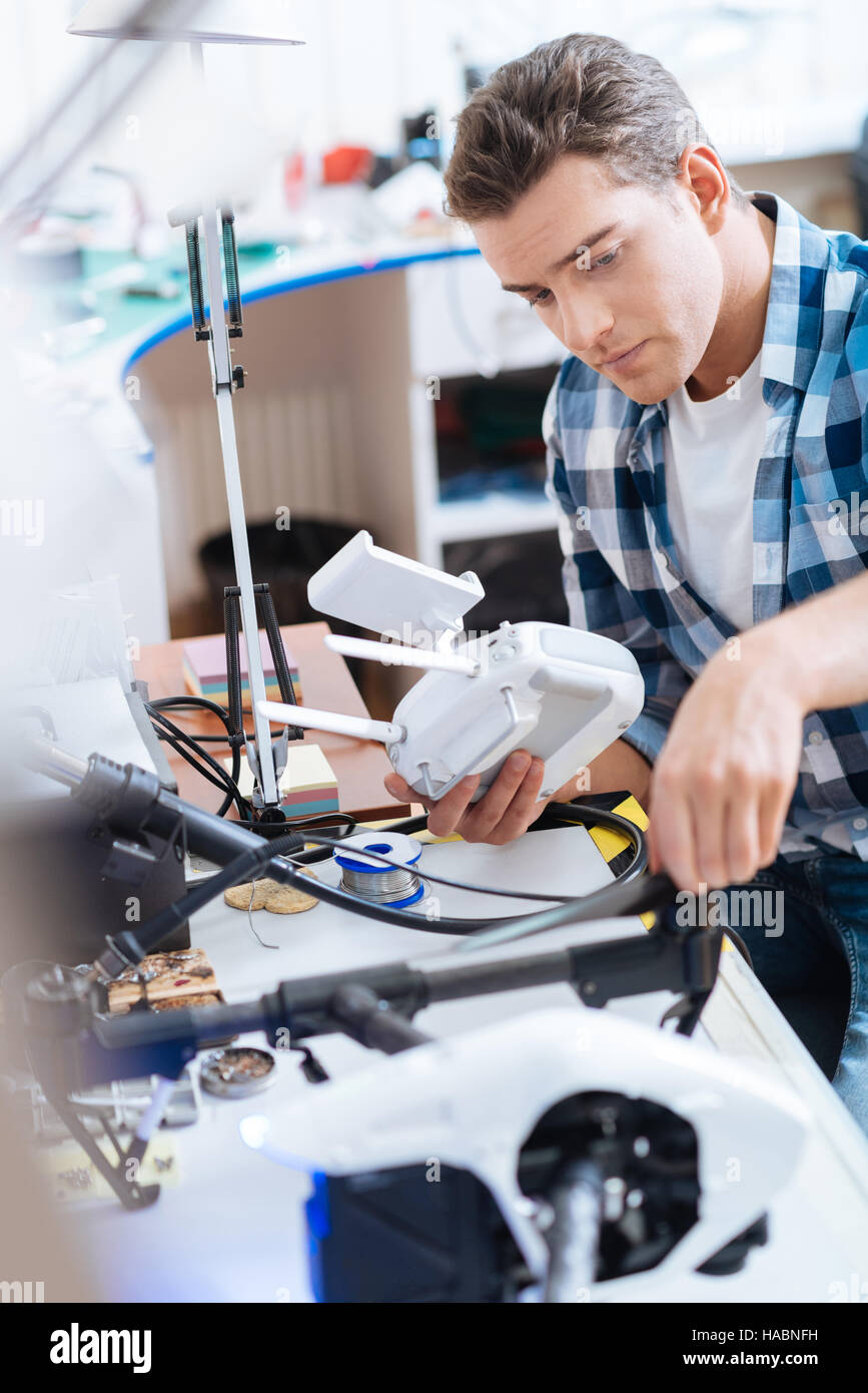 Concentrated man holding remote controller and drone Stock Photo - Alamy