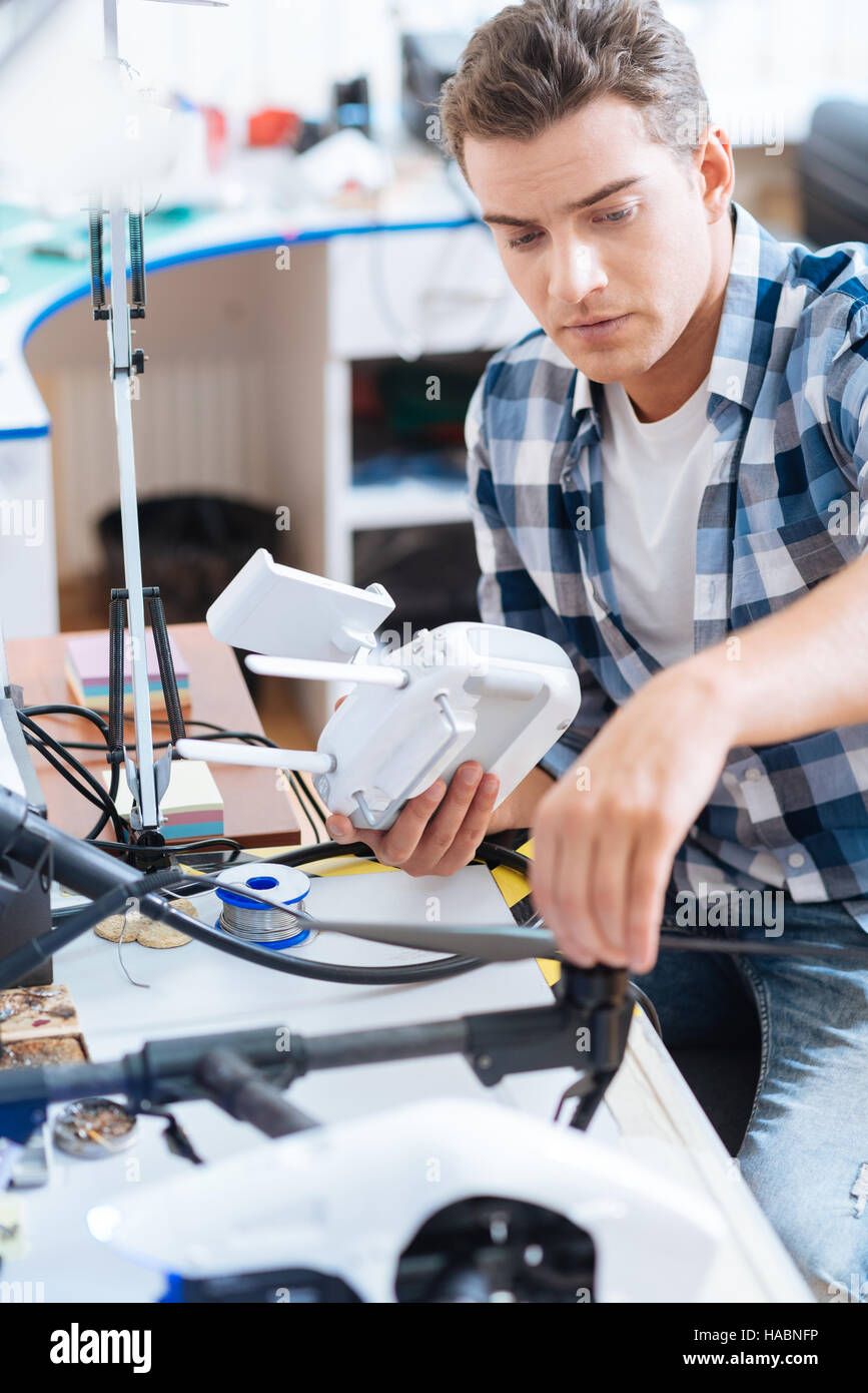 Handsome man using remote controller and drone details Stock Photo - Alamy