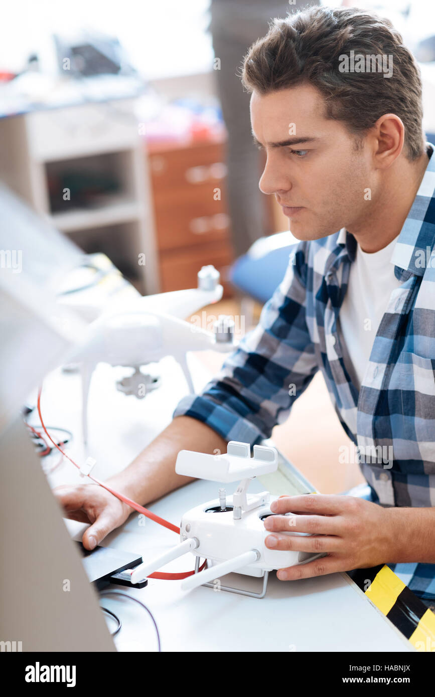 Young man using laptop and programming remote controller Stock Photo ...