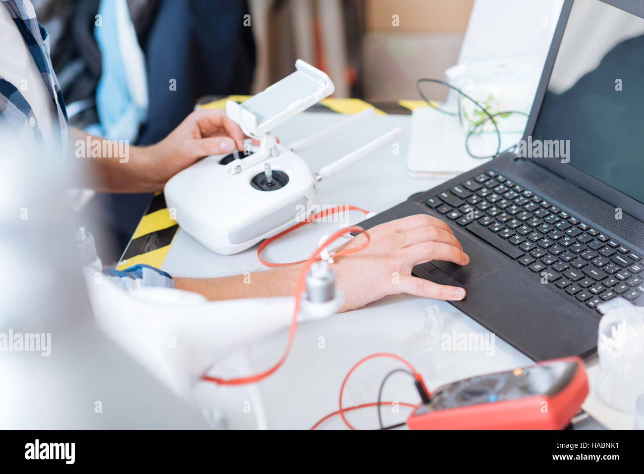 Close up of mans hands using remote controller and laptop Stock Photo ...