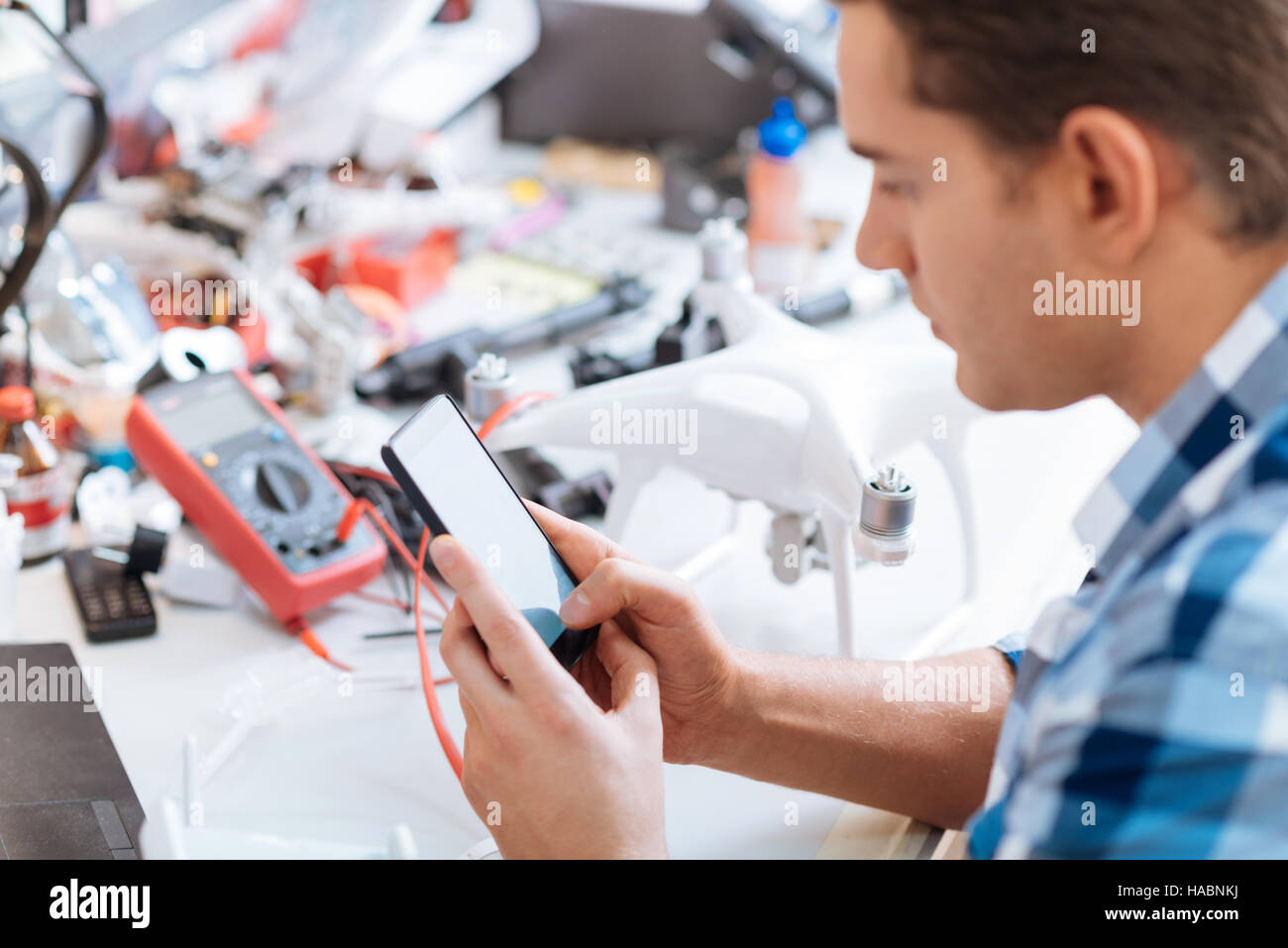 Handsome man using smartphone and laptop Stock Photo - Alamy