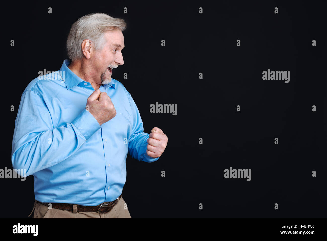 Positive Grey Haired Bearded Man Standing On Black Background Stock