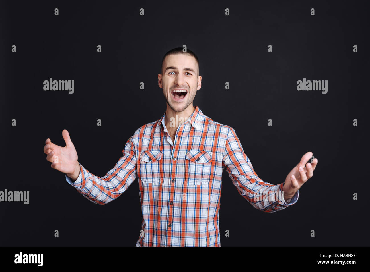 Attractive young man holding hands up Stock Photo - Alamy