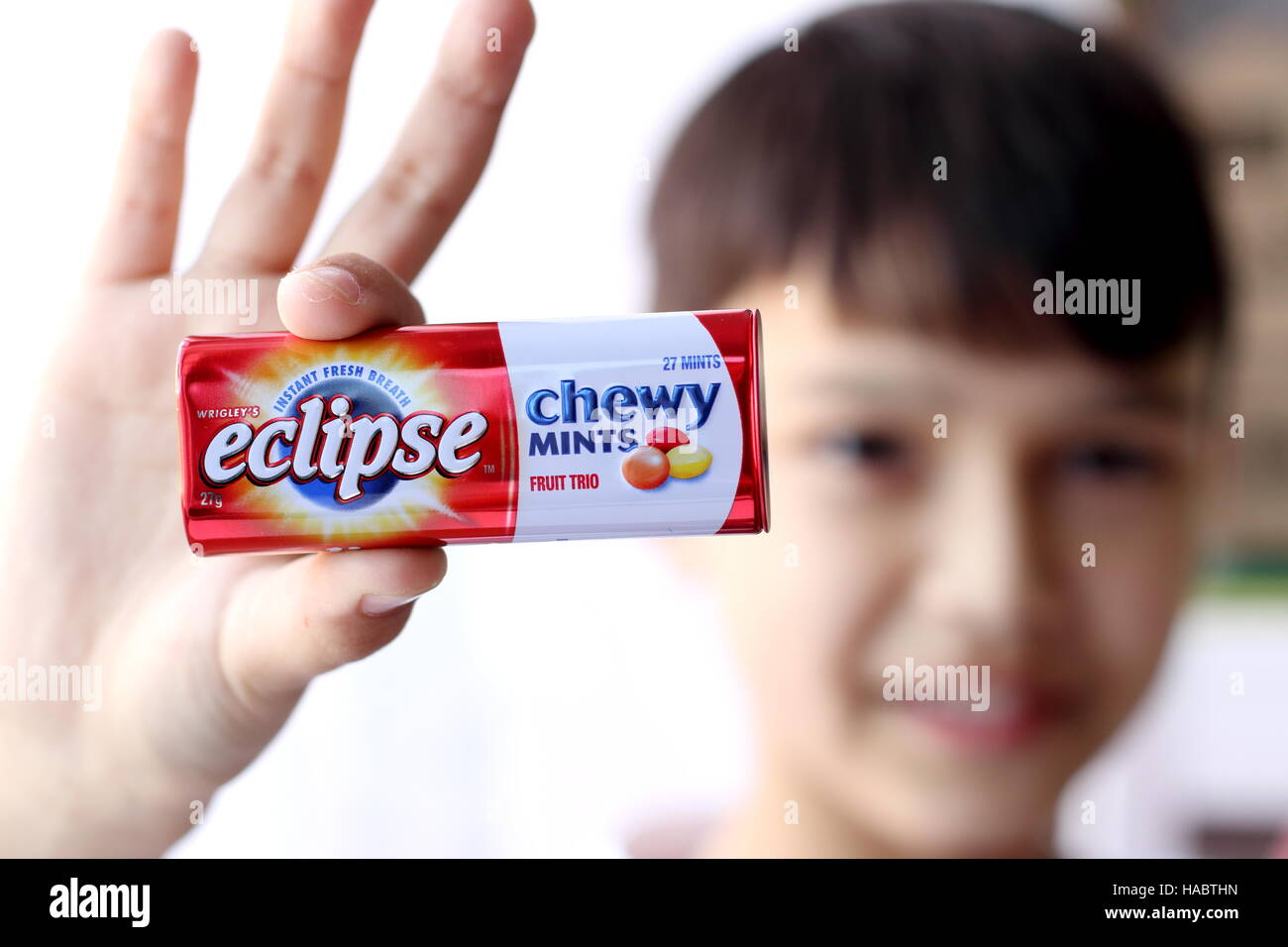 A child hand holding Australian Eclipse Chewy Mints - isolated Stock ...