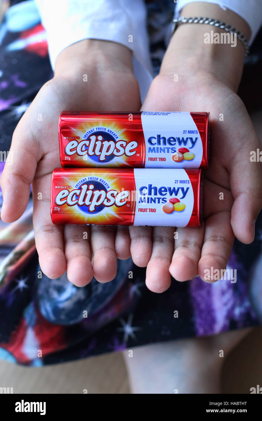 A child hand holding Australian Eclipse Chewy Mints Stock Photo - Alamy