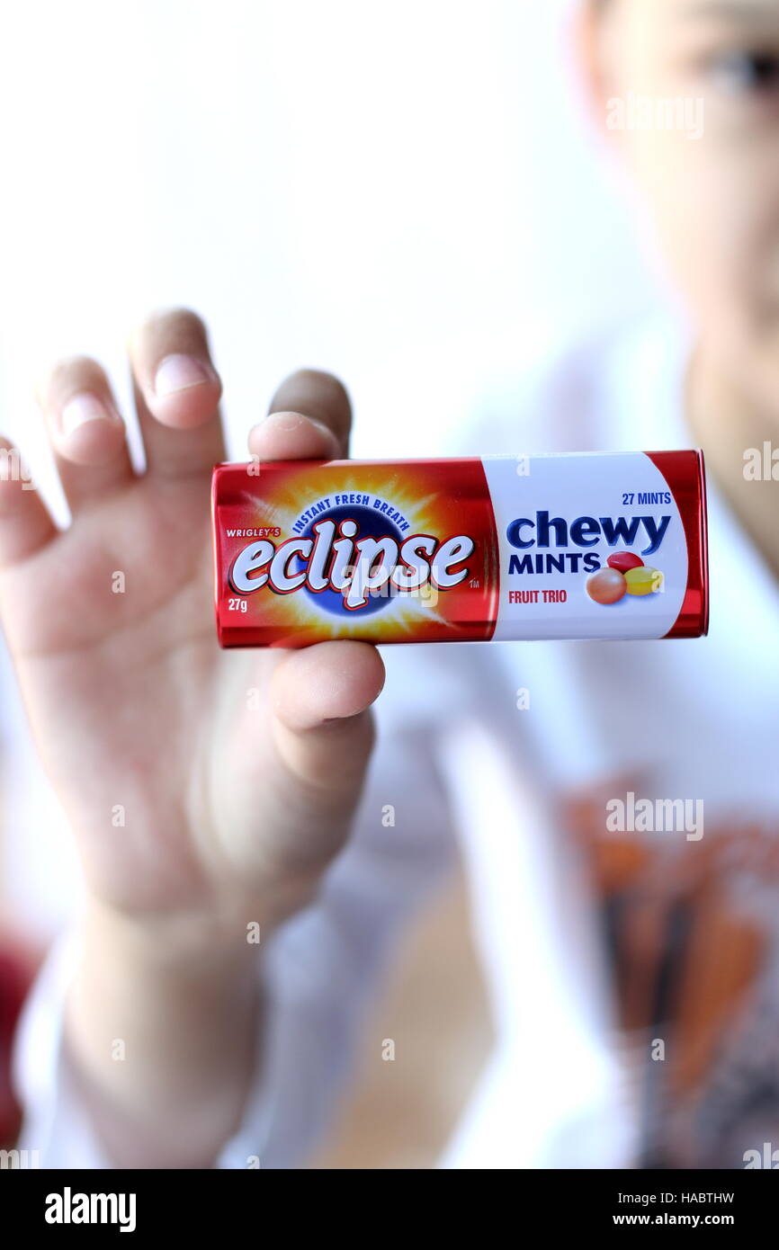 A child hand holding Australian Eclipse Chewy Mints Stock Photo - Alamy