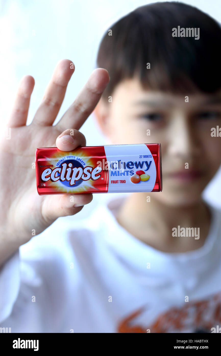 A child hand holding Australian Eclipse Chewy Mints Stock Photo - Alamy