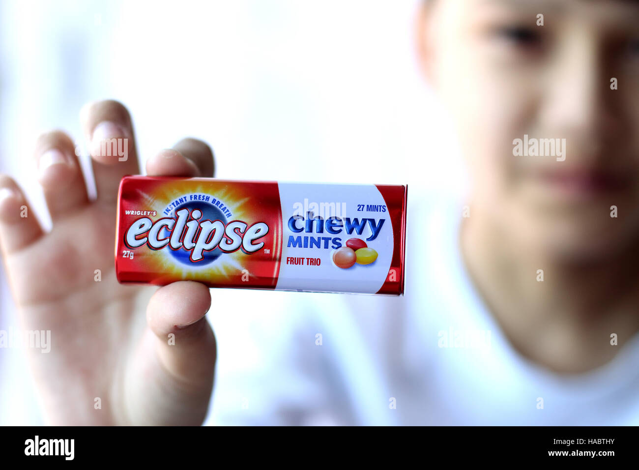 A child hand holding Australian Eclipse Chewy Mints Stock Photo - Alamy