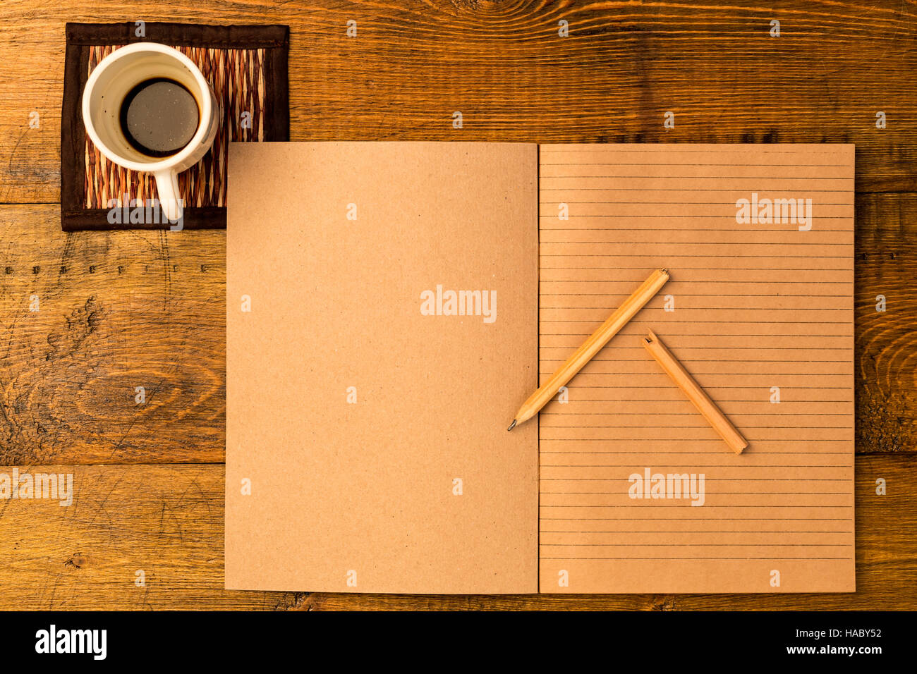 Workplace. Open craft notepad with broken pencil. Cup of coffee Stock ...