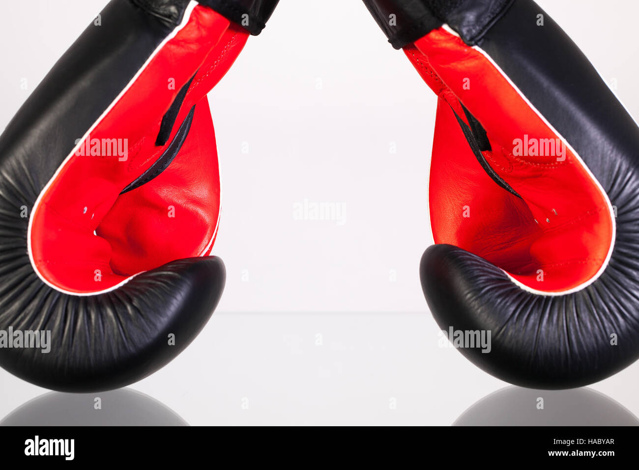 Red and black boxing gloves on a glass table isolated on white ...